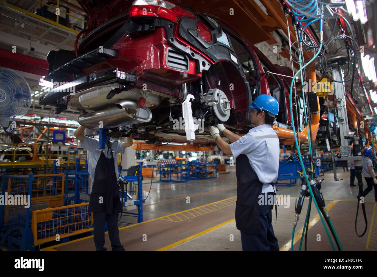 Thai Ford Manufacturing employees work on an assembly line Friday, Aug ...