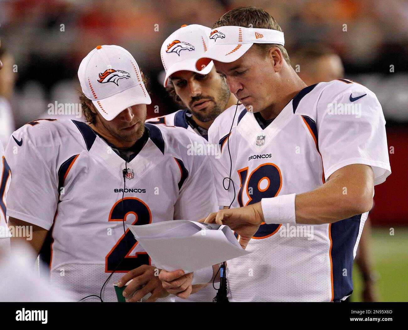Denver Broncos quarterback Peyton Manning (18) goes over plays with ...