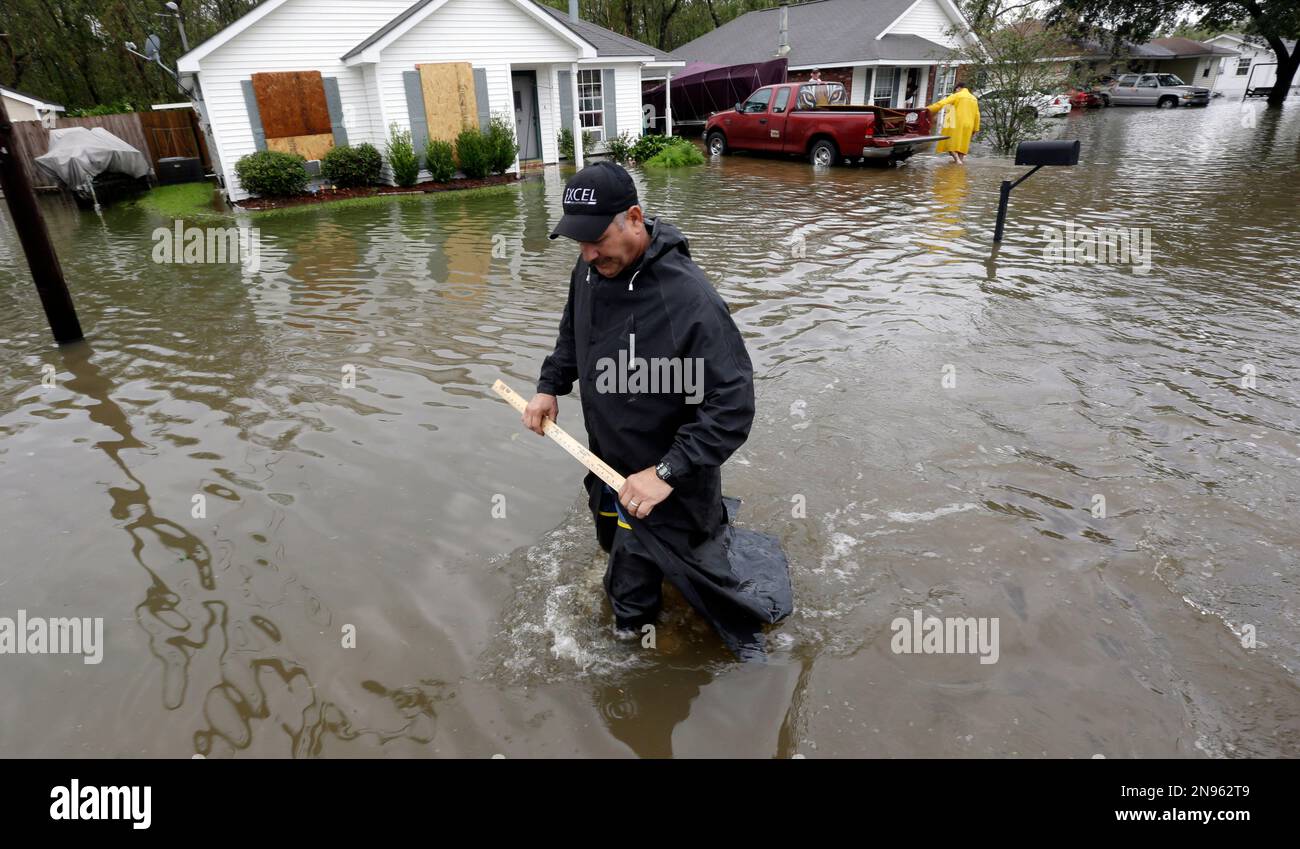 Myron Romondet takes measurements of the flood waters on his street ...