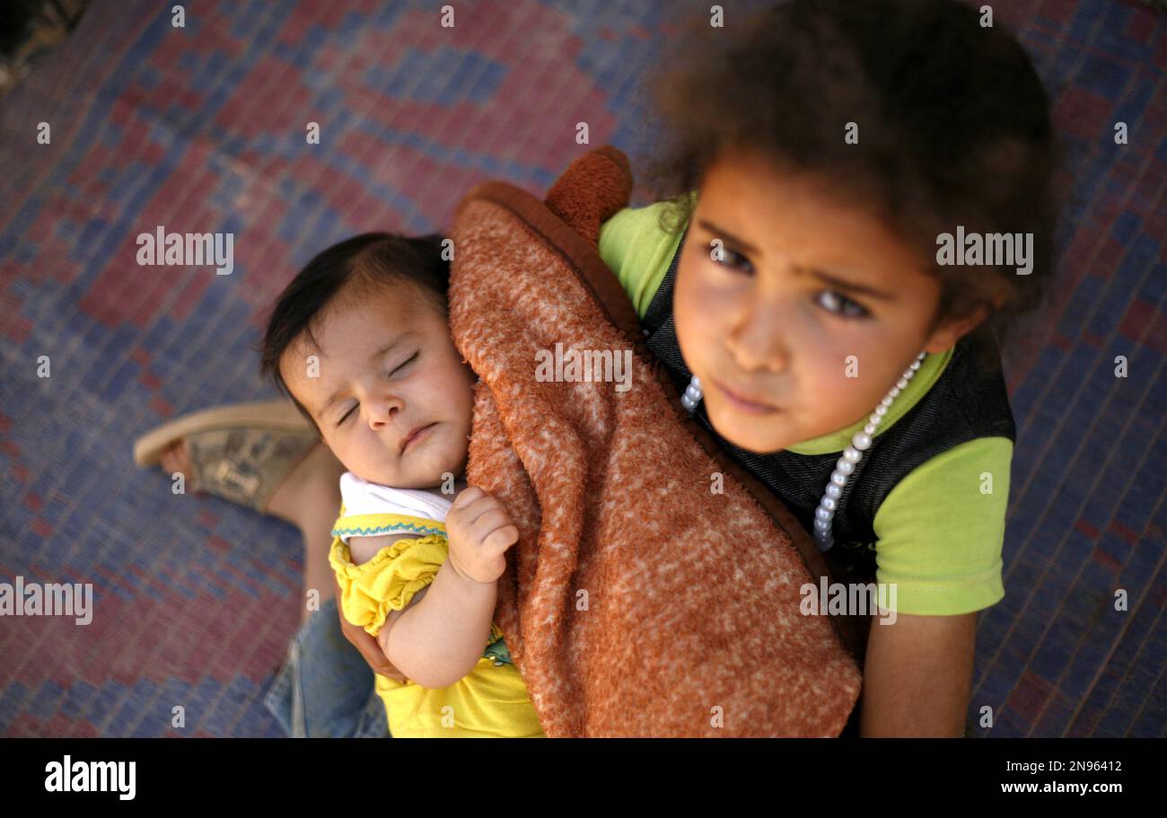 Syrian refugee Maha al Masri, 5, holds her sister, Rana, who was born ...