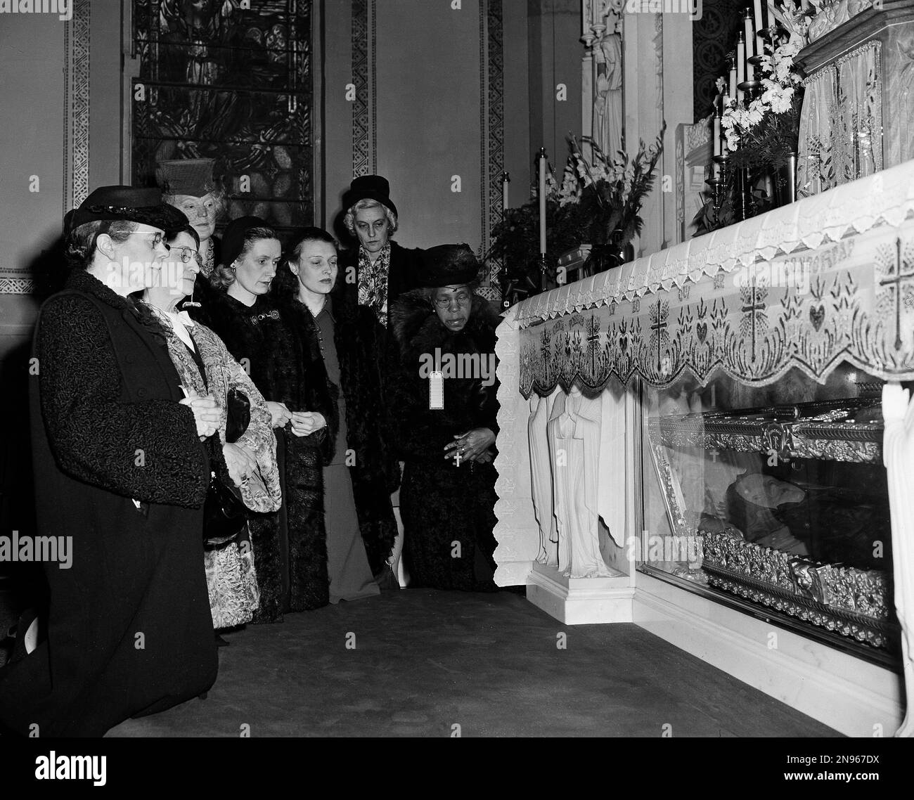 Members of a pilgrimage from around the U.S. pause before the enshrined ...