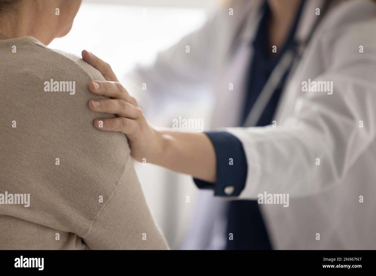 Hand of geriatrician doctor touching shoulder of elderly patient woman ...