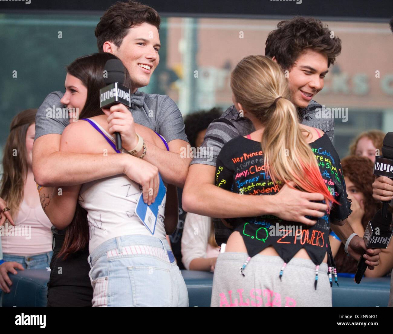 Singer Zachary Porter and musician Cameron Quiseng of the band Allstar Weekend hug fans during ...