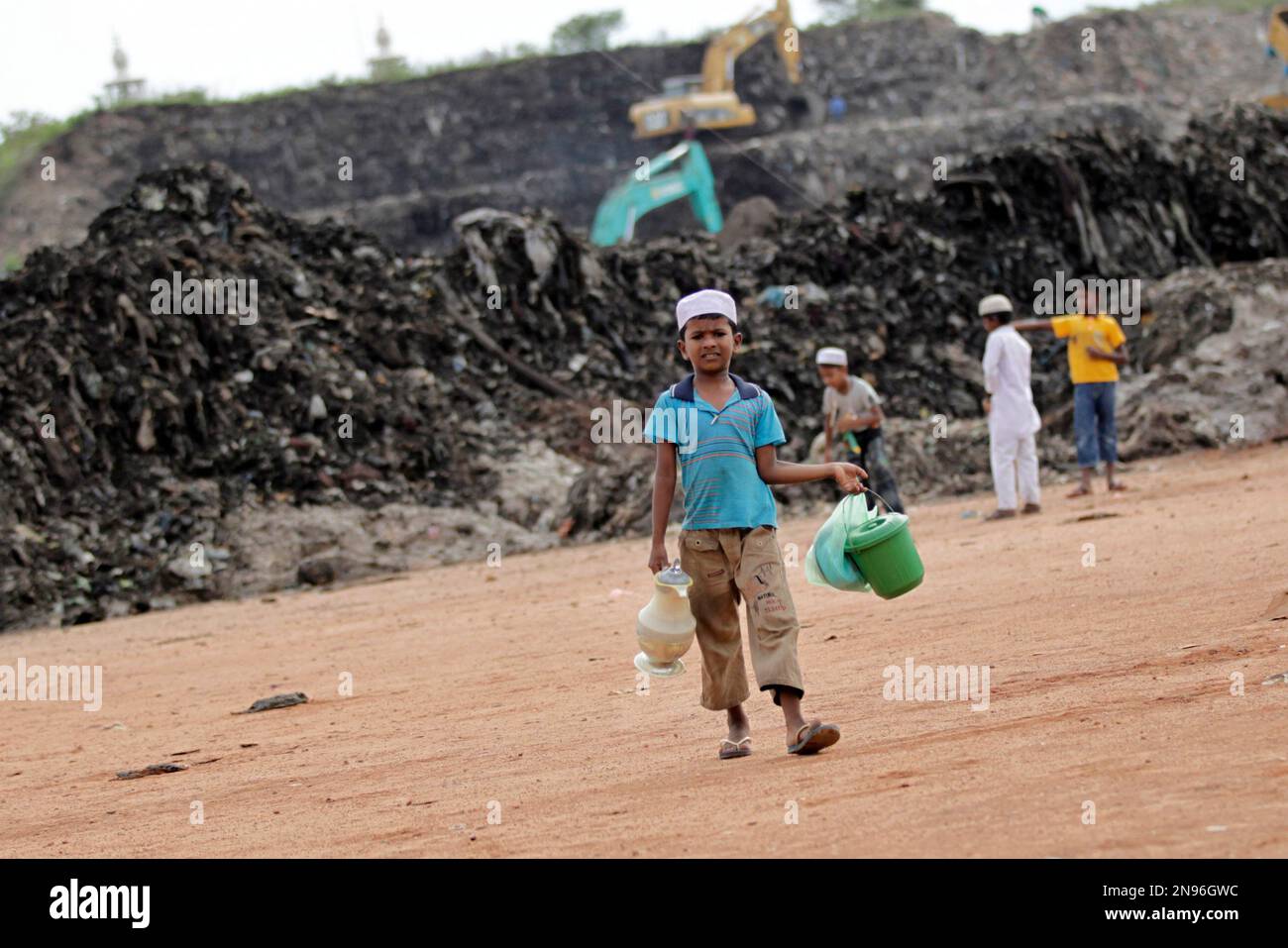 A Sri Lankan Muslim boy carrying food containers walks through his ...