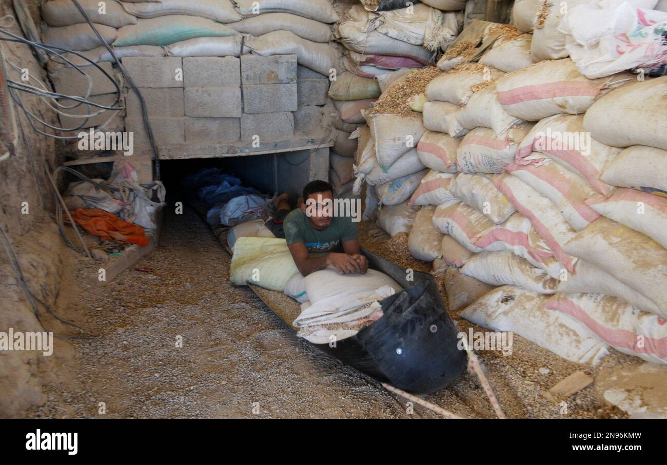 A Palestinian smuggler brings construction materials through a ...
