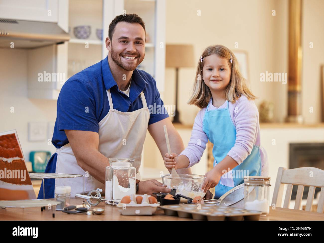 Bake your loved ones some treats. a young man helping his daughter stir ...