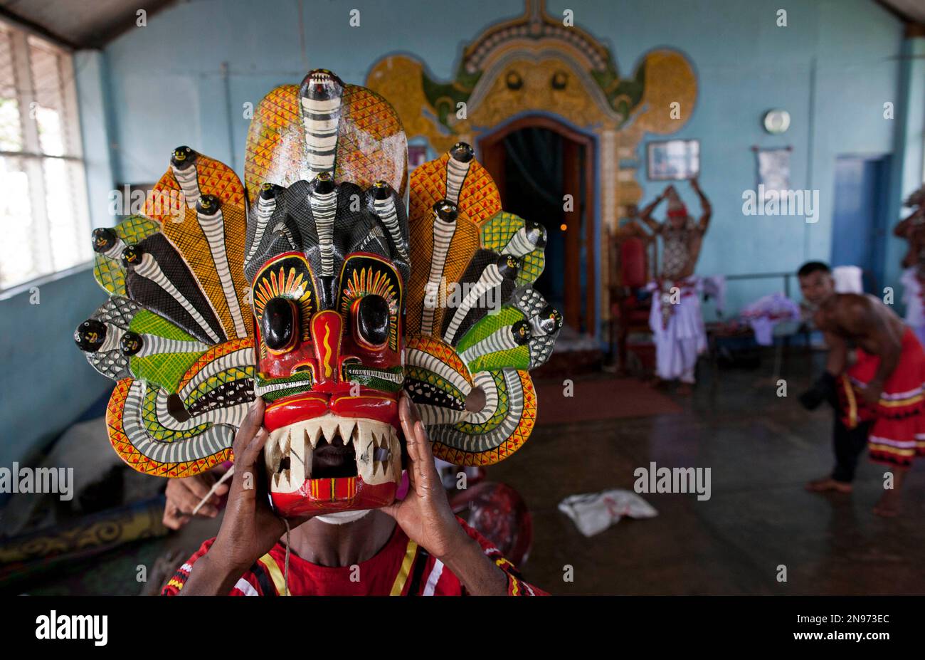 A Sri Lankan prisoner helps another to wear a traditional mask ahead of ...