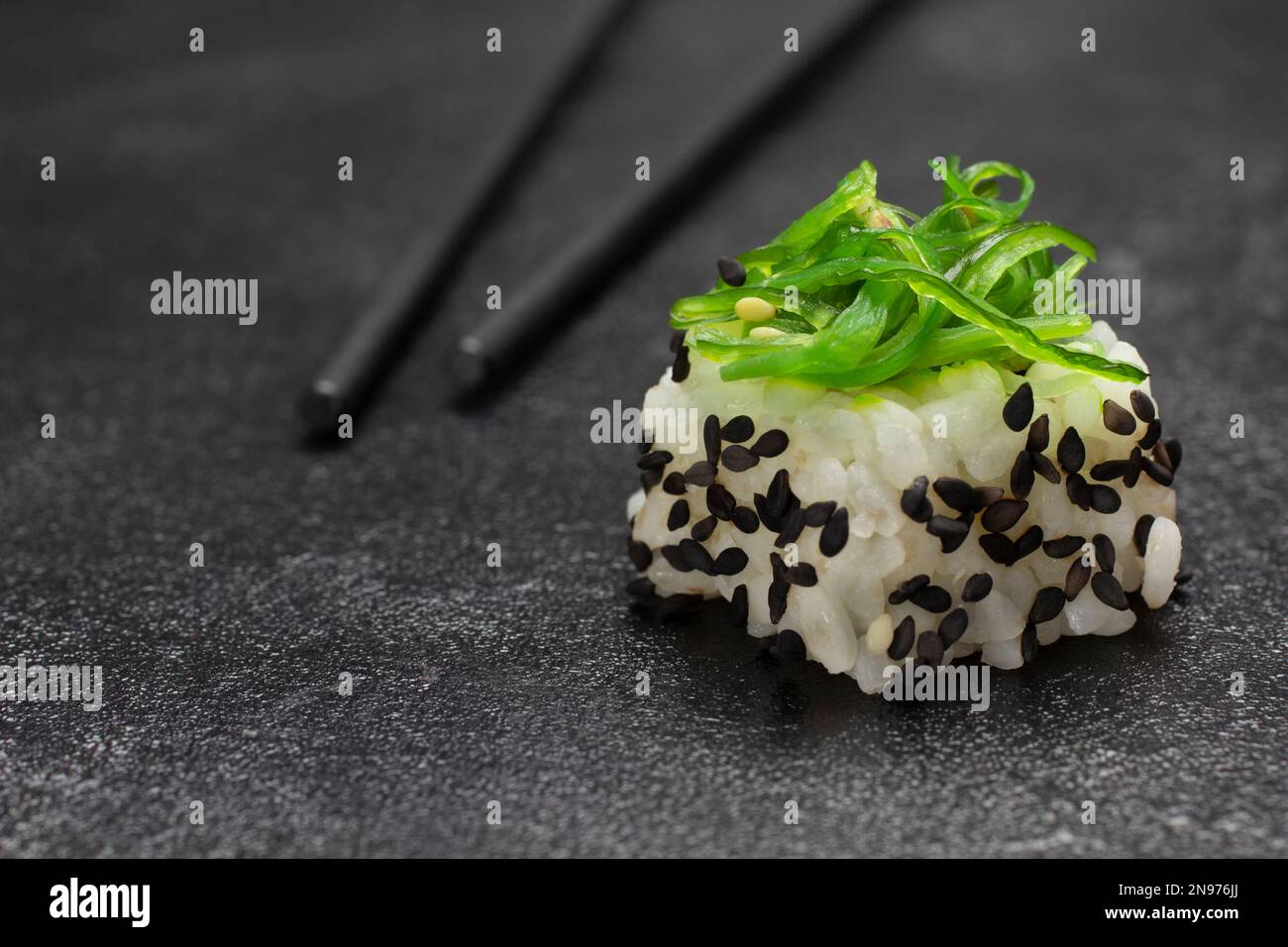 Sushi with green algae. Food sticks. Close up. Black background Stock ...