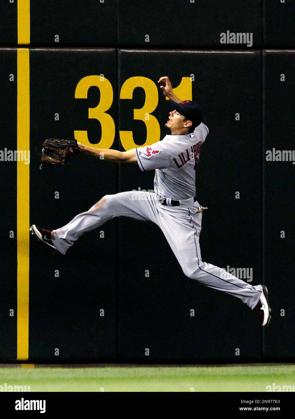 Cleveland Indians left fielder Brent Lillibridge leaps for a fly ball ...