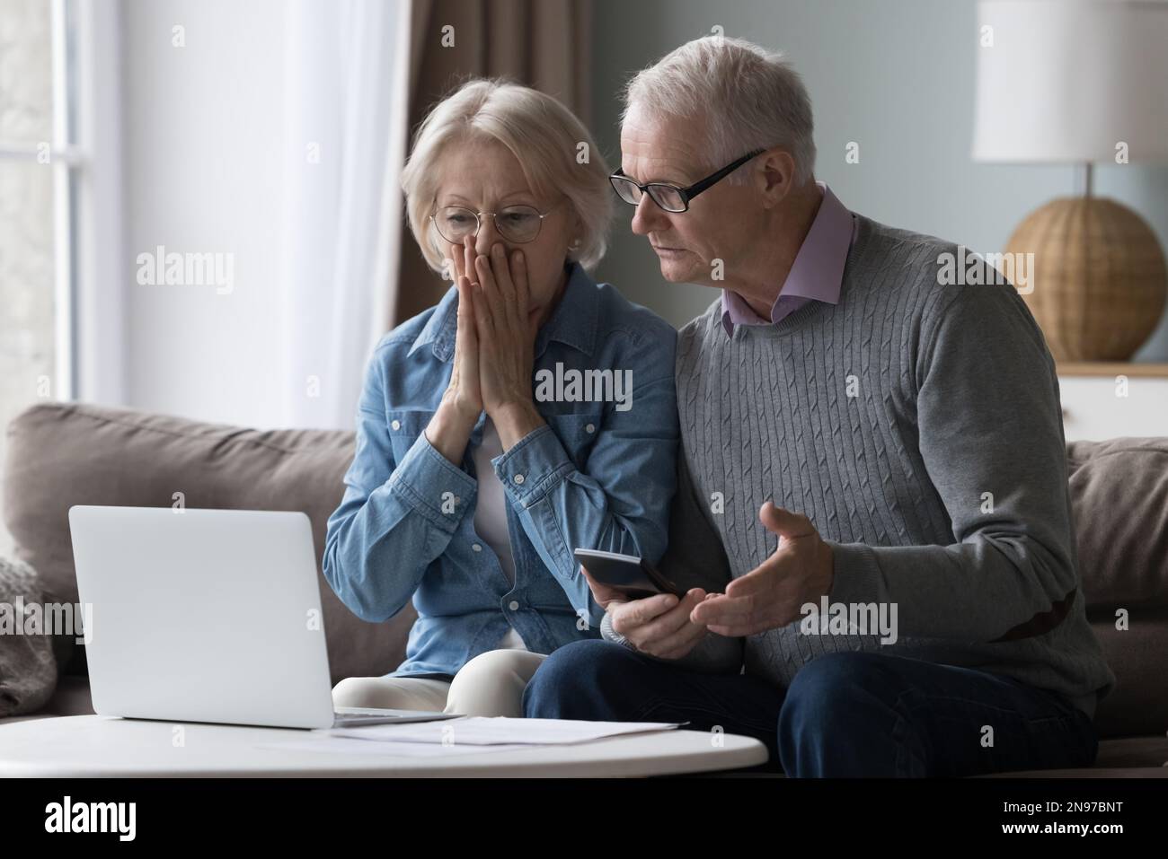 Shocked upset elderly couple getting bad news, finding fraud Stock ...