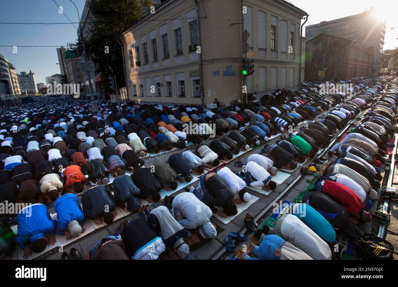 Muslim men, bowing toward Mecca, perform Eid al-Fitr prayers that marks ...