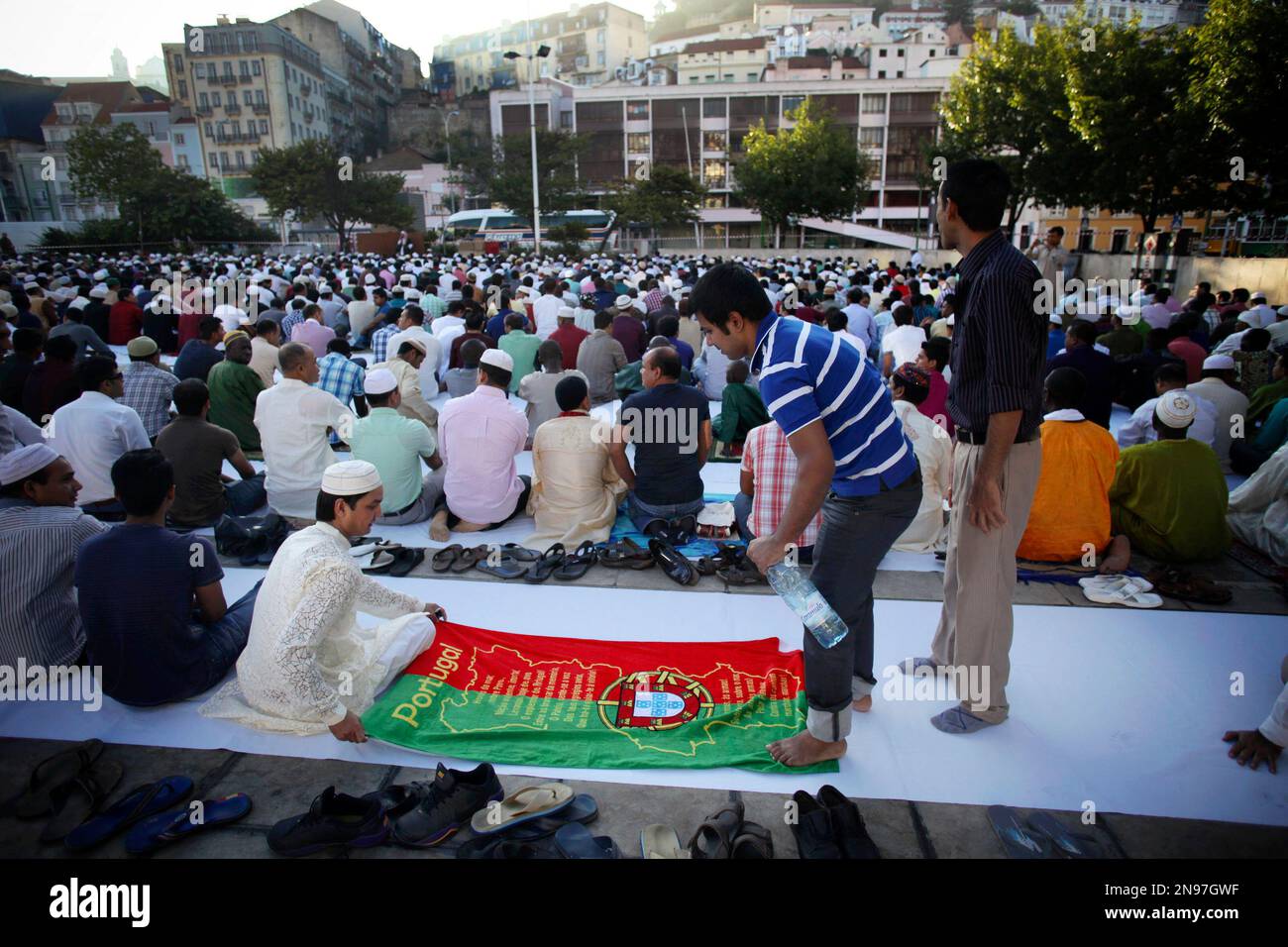 Muslim worshippers place on the ground a piece of cloth with the map of ...