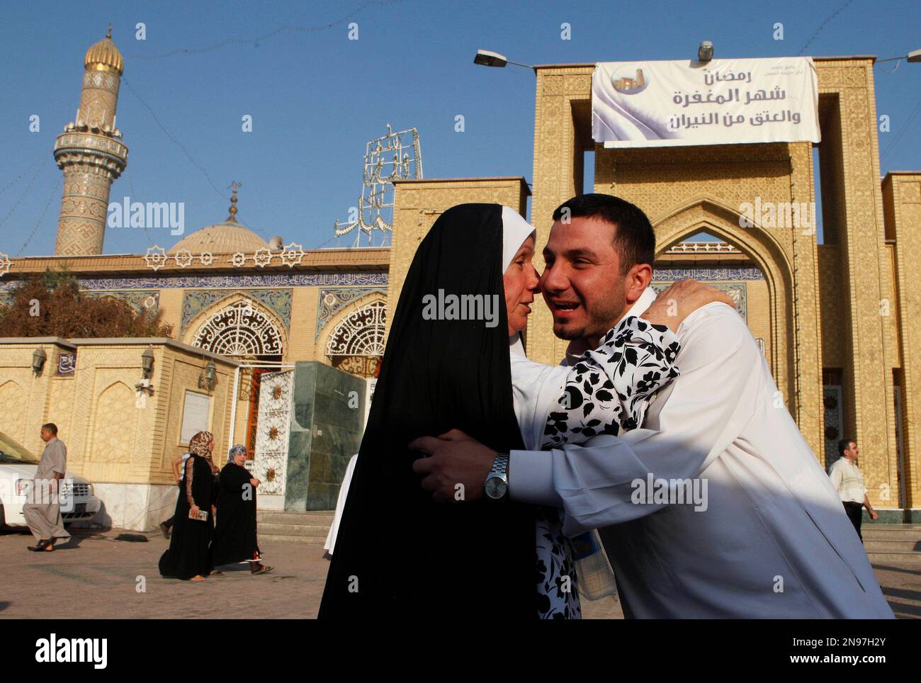 Iraqi Sunni Muslims exchange greetings after Eid prayers outside Abu ...