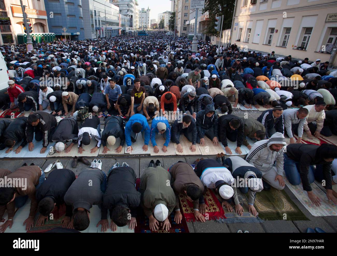 Muslim men, bowing toward Mecca, perform Eid al-Fitr prayers that mark ...