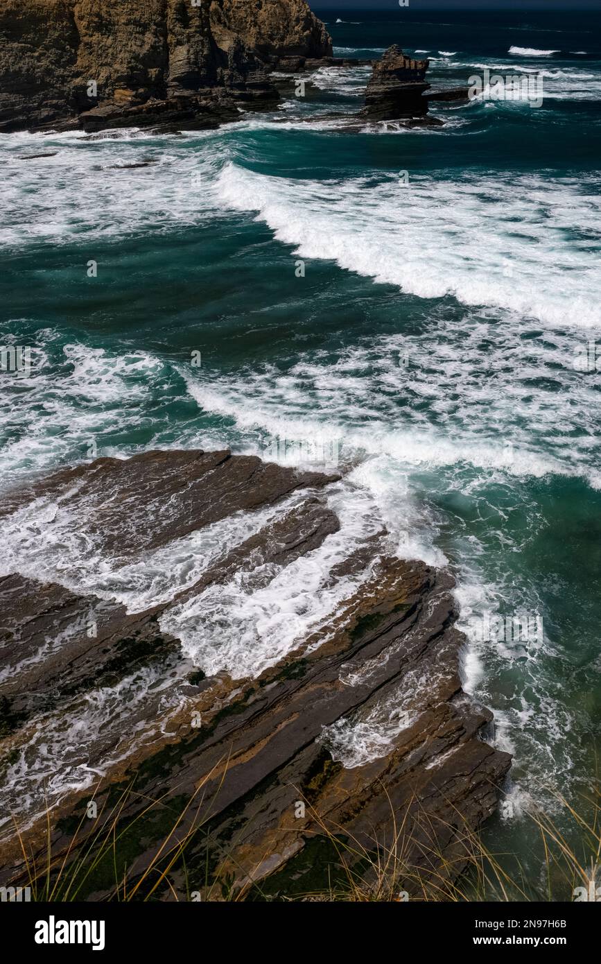 Green sea and white surf: surging Atlantic waves swirl around stack ...