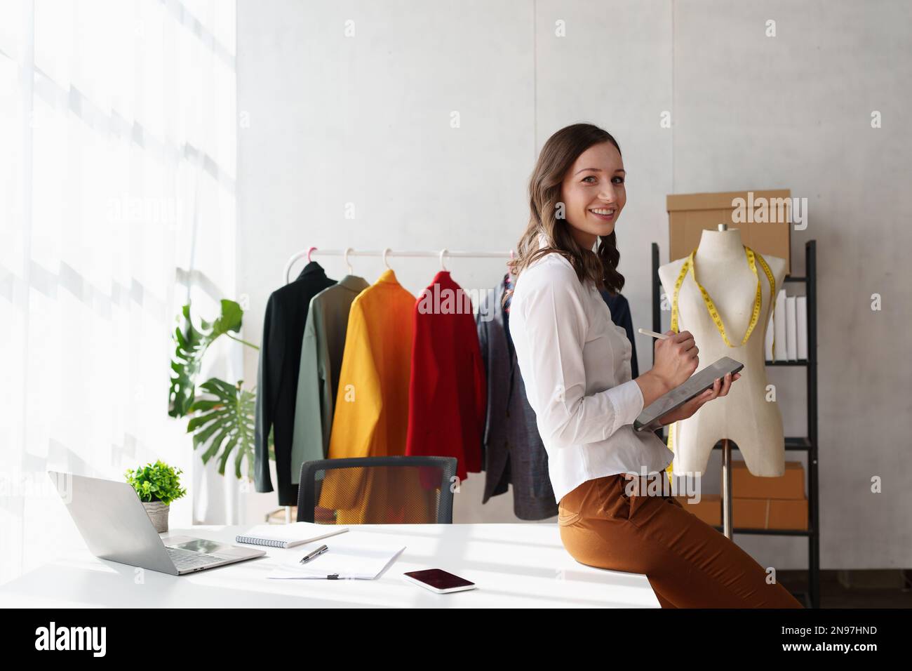 Beautiful young professional stylist working at design studio interior ...