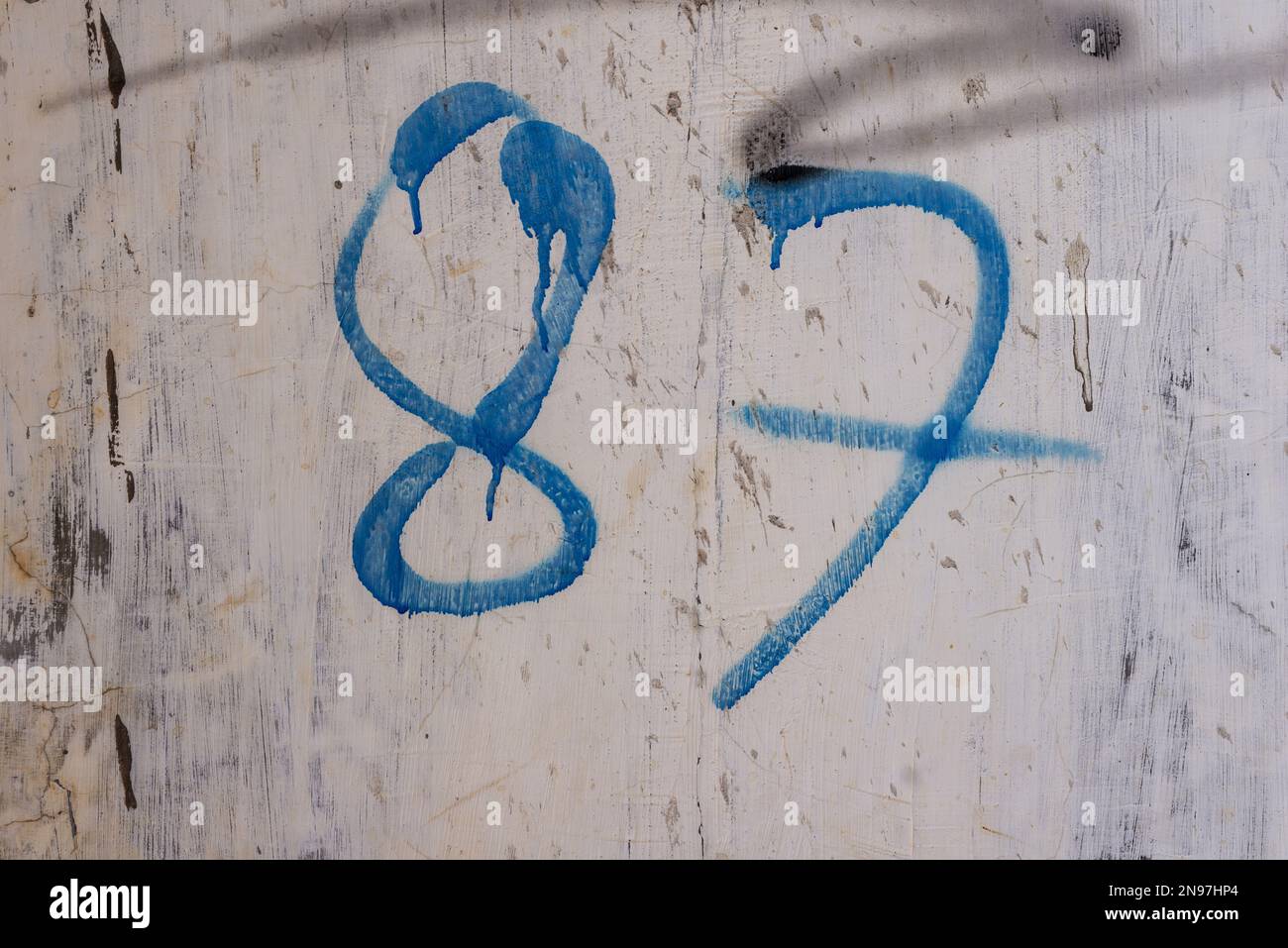 A blue number 87 paint on a dirty wall Stock Photo - Alamy