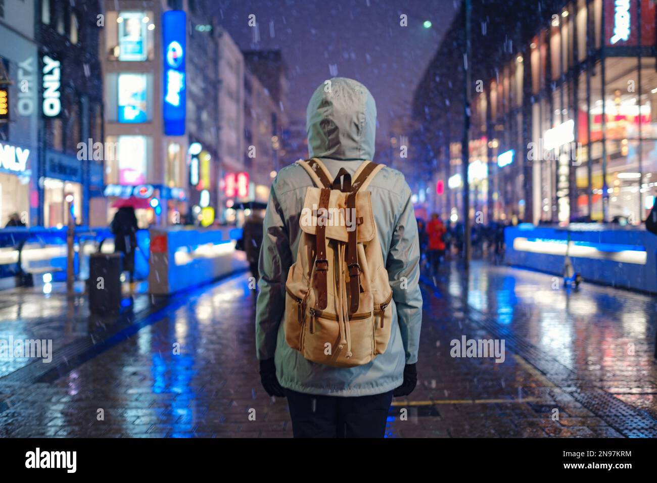 snowfall woman in a blue jacket and yellow hat christmas outside, city ...