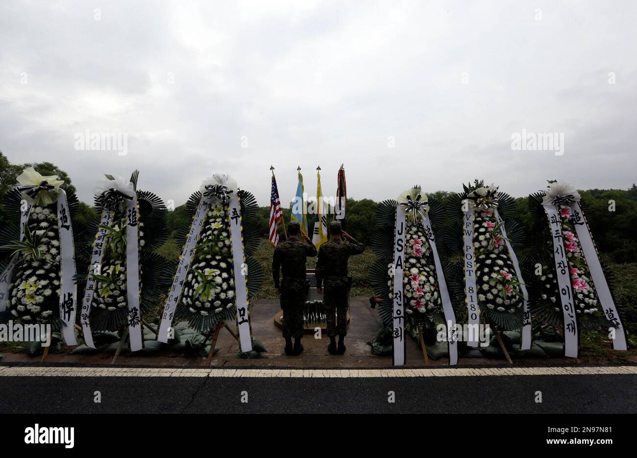 Two South Korean soldiers salute after they lay wreaths during the 36th ...
