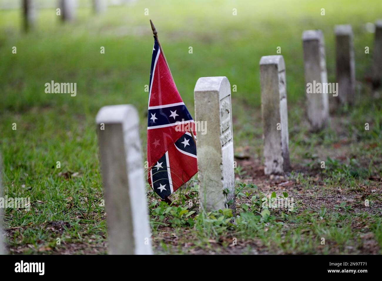 A confederate flag is seen at a tombstone on the cemetery at Beauvoir ...