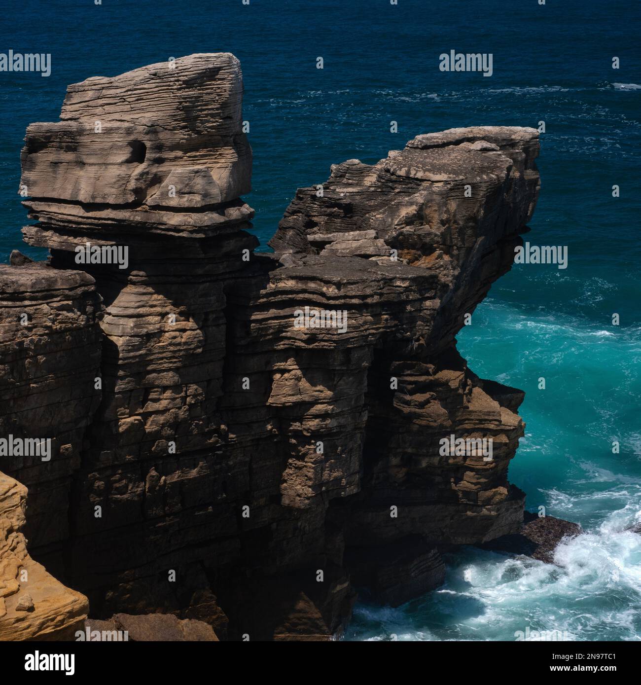 Square view of two ancient sisters: stratified stack rock or sea pillar ...