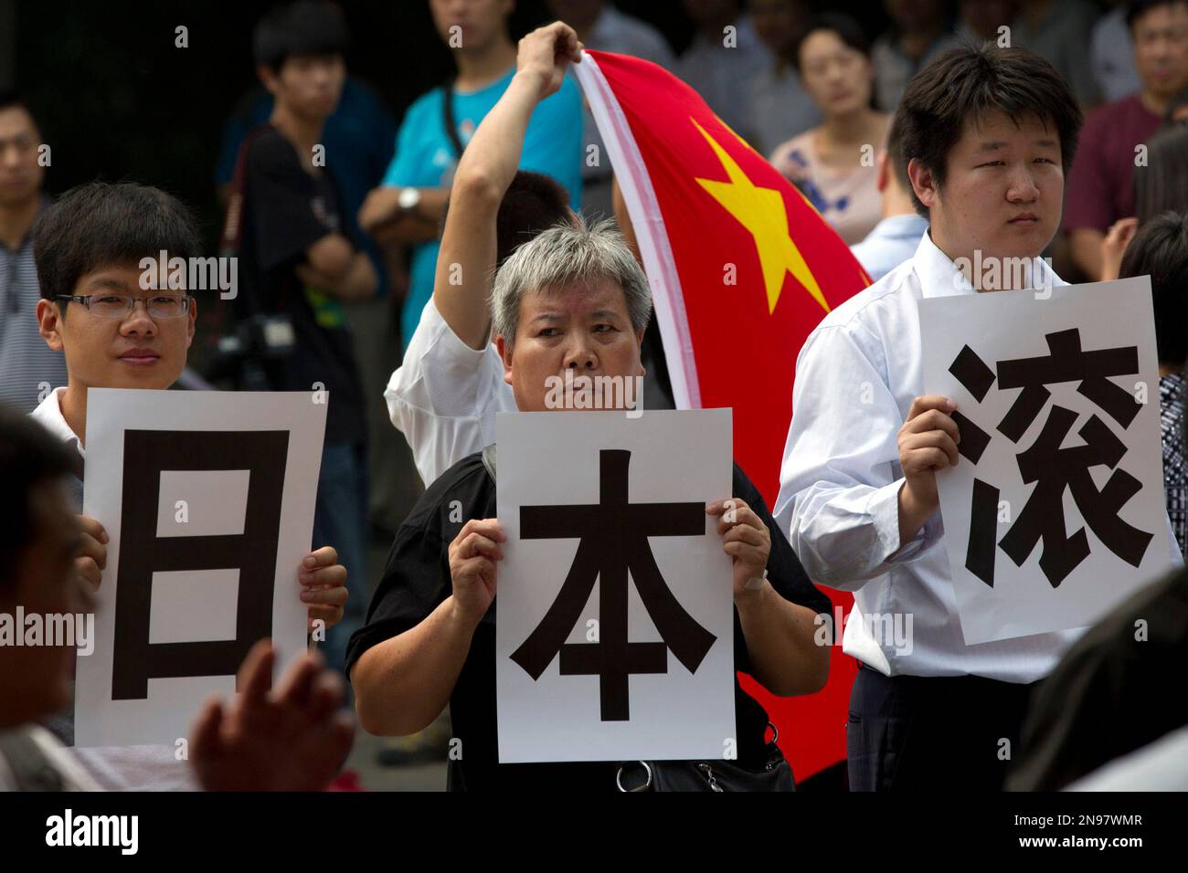 Anti-Japan protesters hold printed Chinese characters, that reads ...