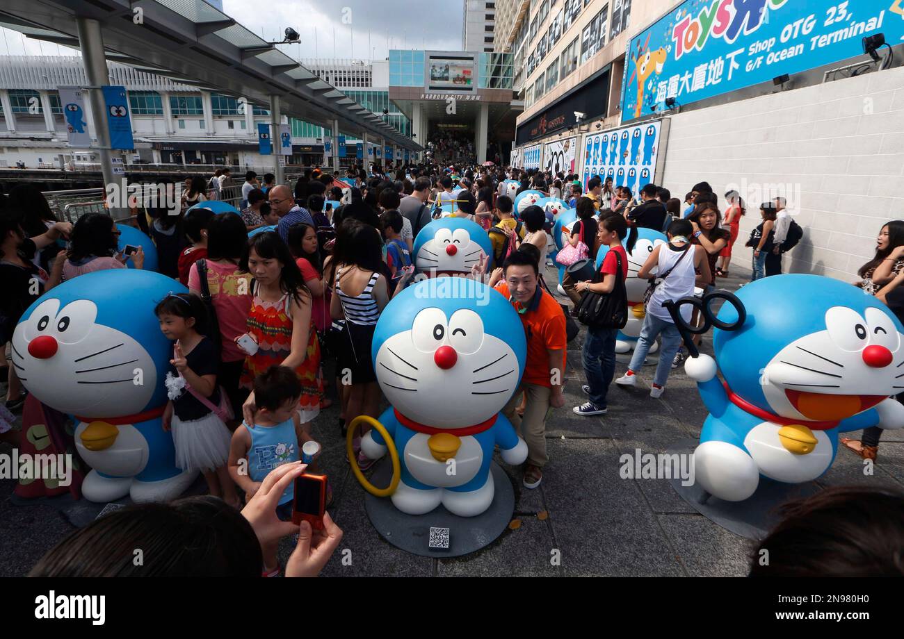 Fans pose with figures of Doraemon, a famous Japanese cartoon character ...