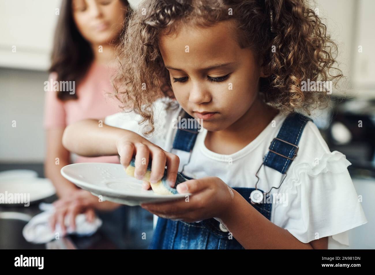 Making sure its squeaky clean. an adorable young girl standing and ...