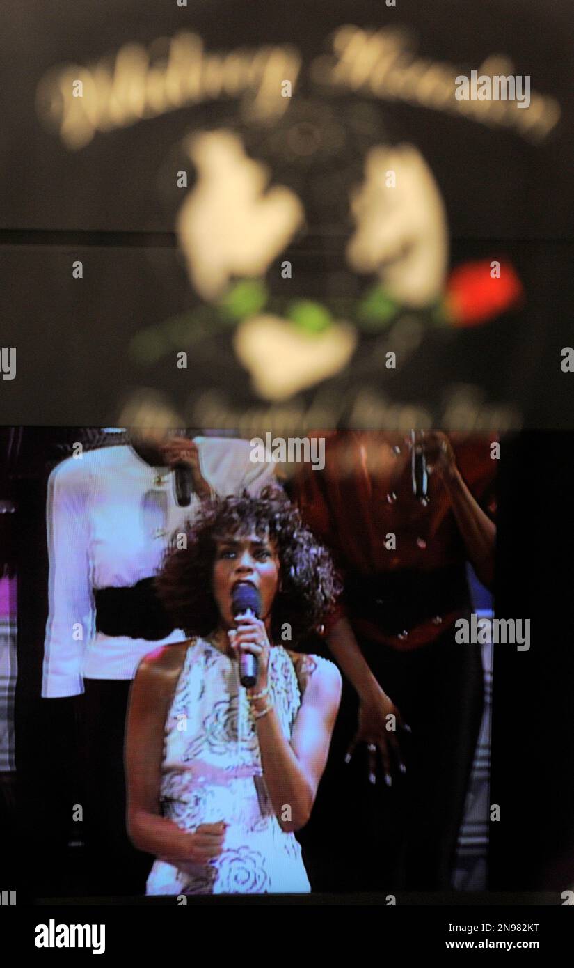 A video of Whitney Houston in performance is reflected on a display ...