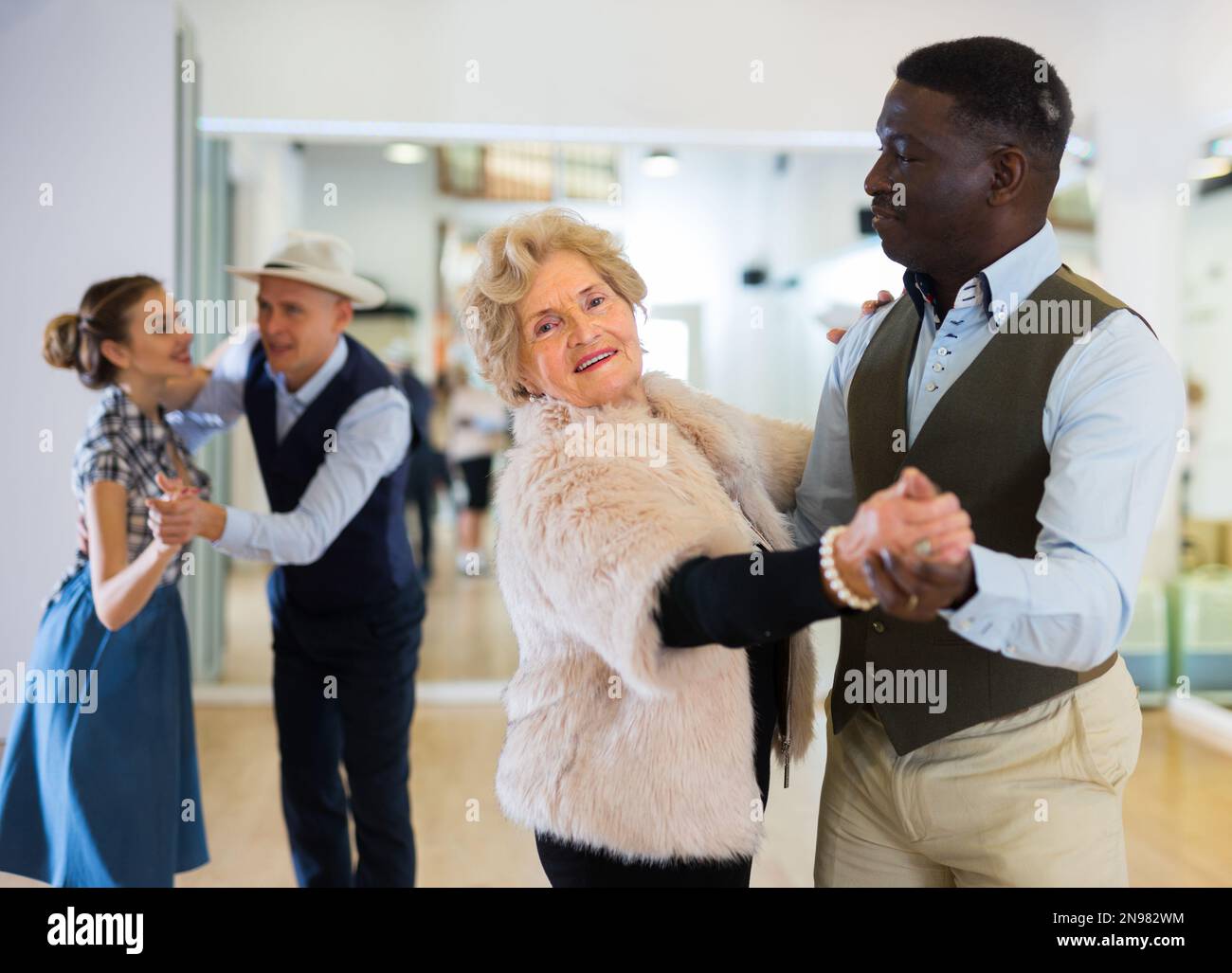 Elderly woman learning ballroom dancing in pair in dance studio Stock ...