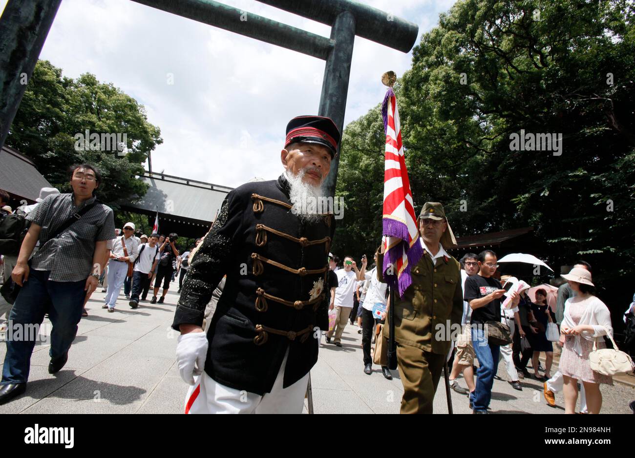 A veteran dressed in a military uniform, center, accompanied by a man ...