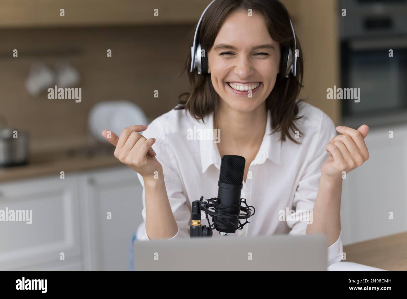 Happy blogger girl in wireless headphones using big microphone Stock ...