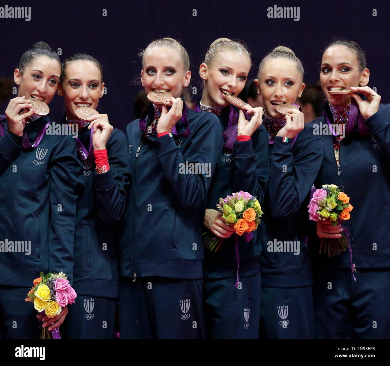 Members of the team from Italy bite their bronze medals during the ...