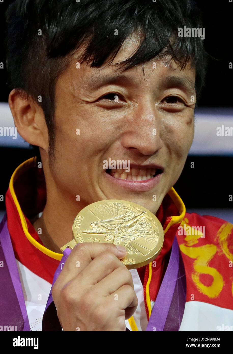 Zou Shiming, of China, shows off his gold medal for winning the light ...