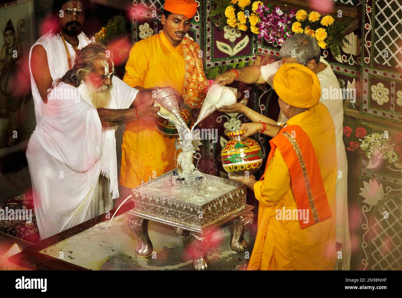 Hindu priests pour curd on an idol of Hindu God Krishna in a religious ...