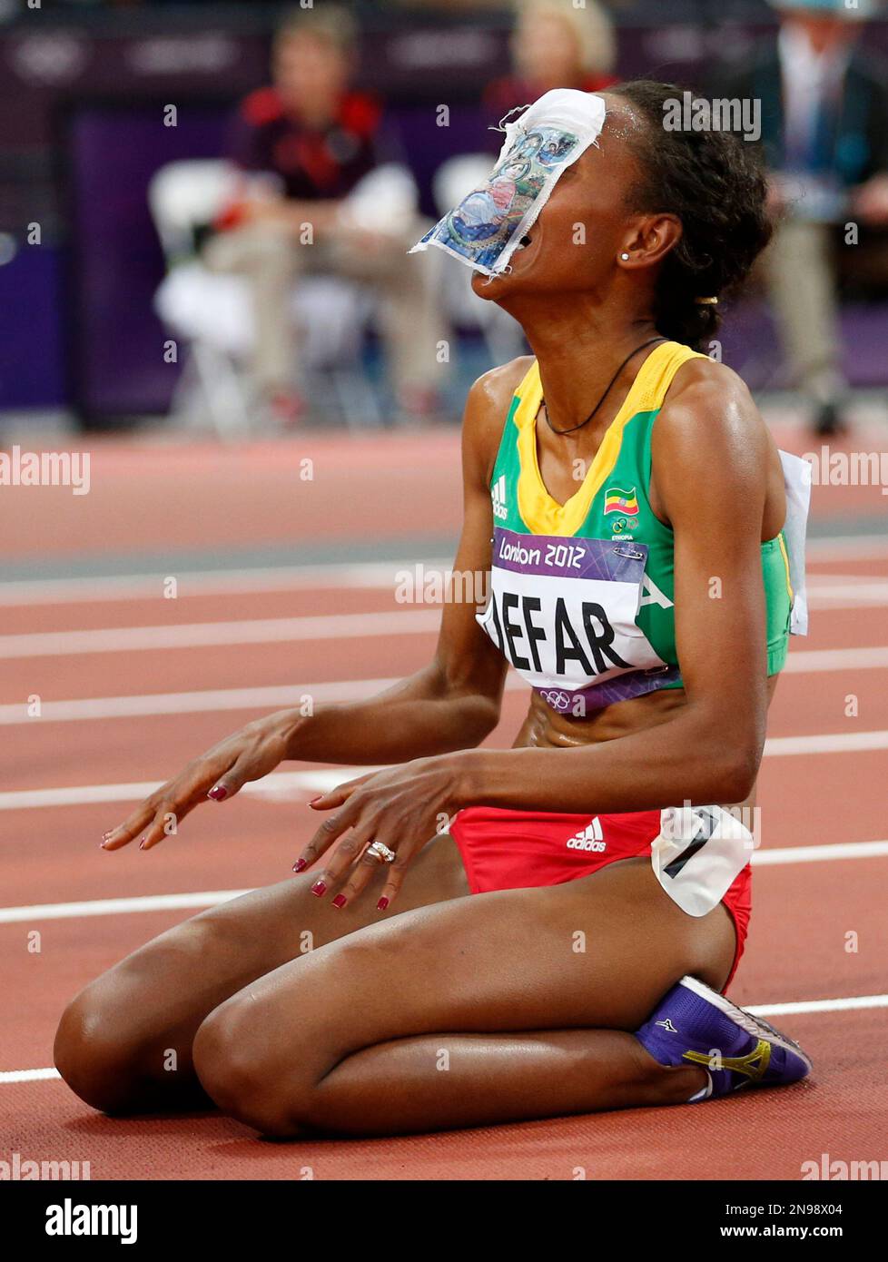 Ethiopia's Meseret Defar holds up a picture to her face after she won ...
