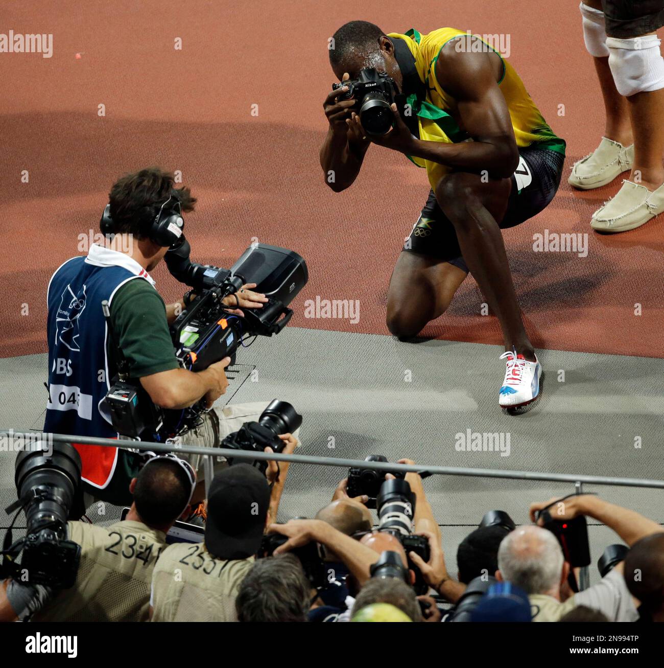 Jamaica's Usain Bolt uses a photographers camera as he takes pictures ...