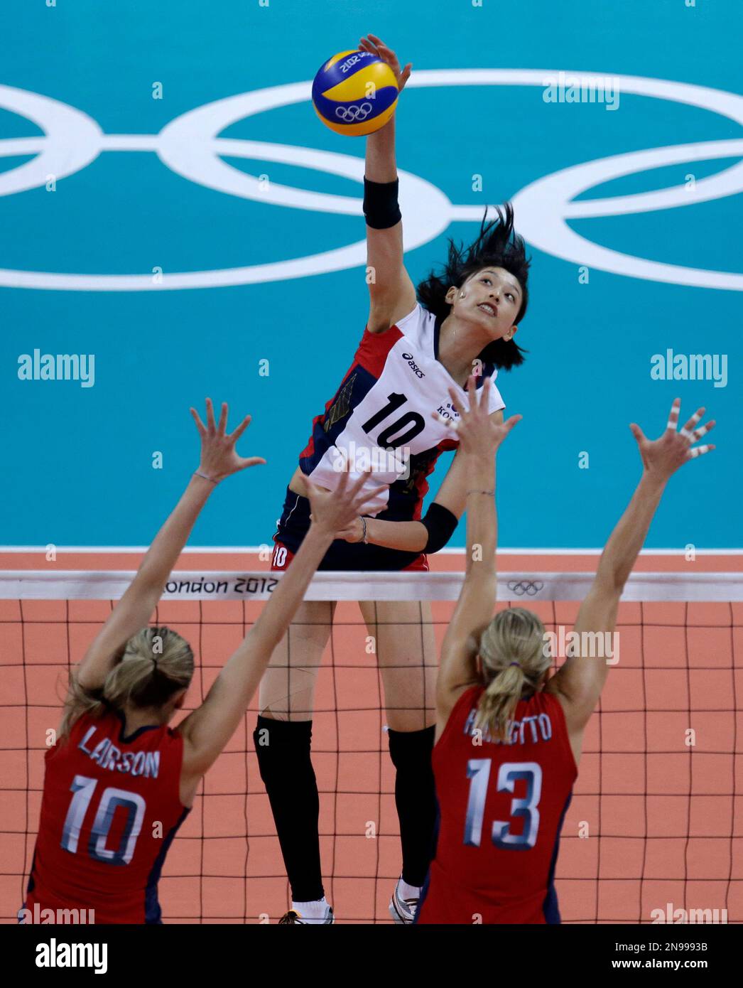South Korea's Kim Yeon-koung, top, spikes the ball over United States ...