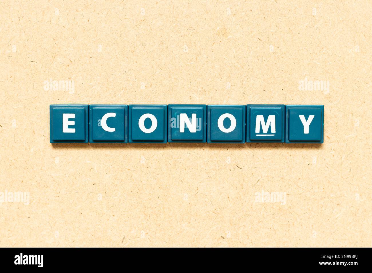 Tile alphabet letter in word economy on wood background Stock Photo - Alamy