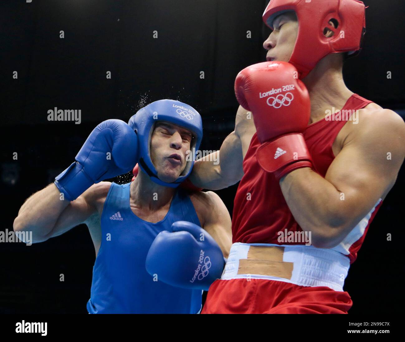 Kazakhstan's Adilbek Niyazymbetov, right, fights Iran's Ehsan Rouzbahani during their men's ...