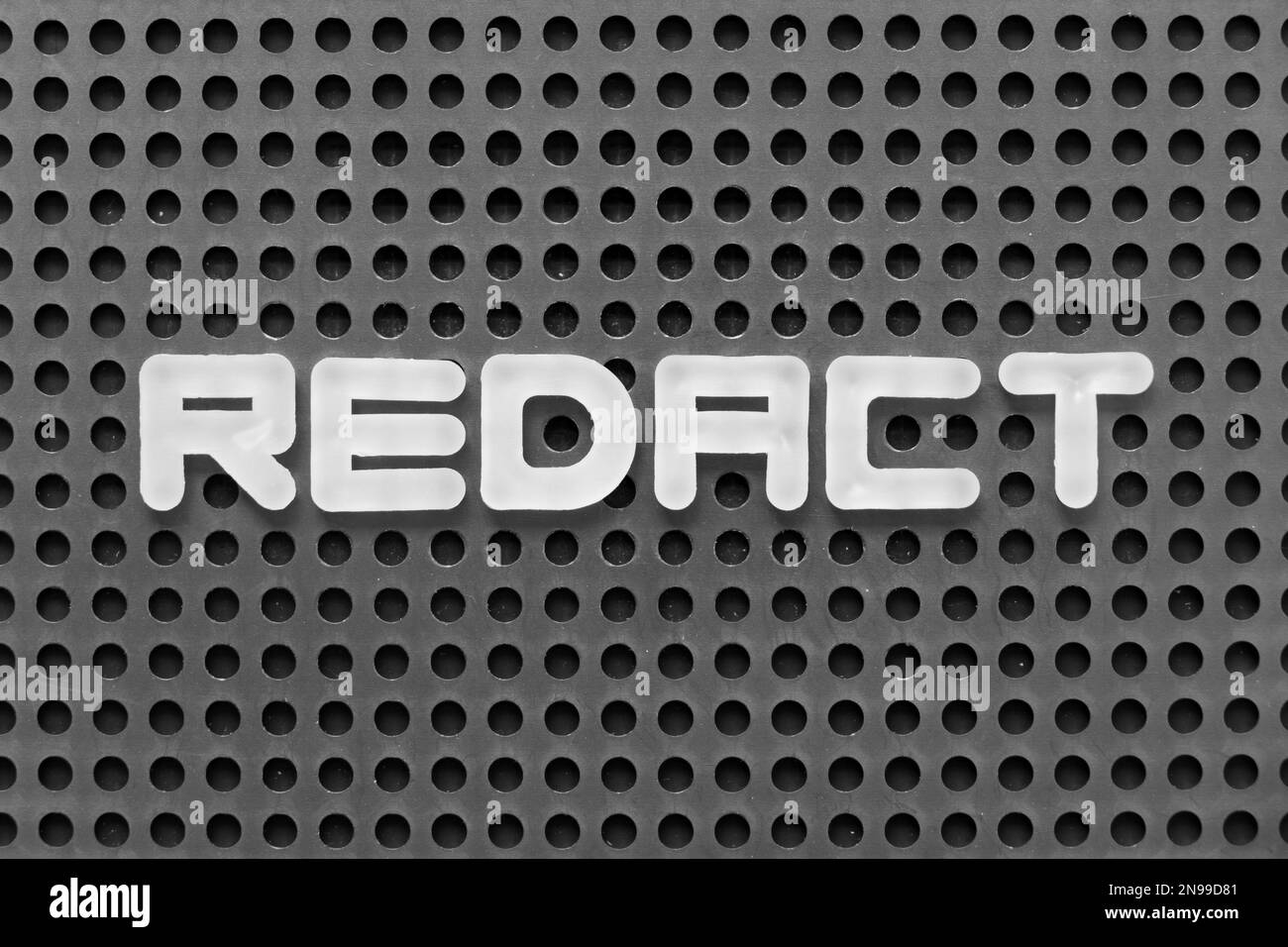White alphabet letter in word redact on black pegboard background Stock ...