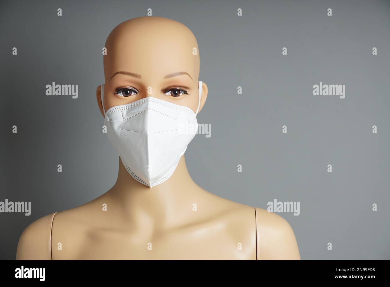 a shop window mannequin or display dummy head wearing FFP2 face maskas ...