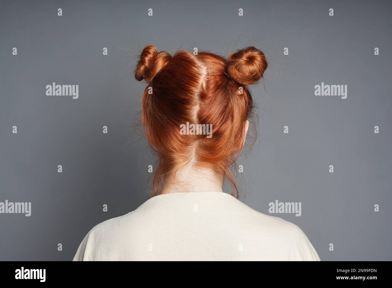 back view of red-haired woman with messy space buns hairstyle Stock ...