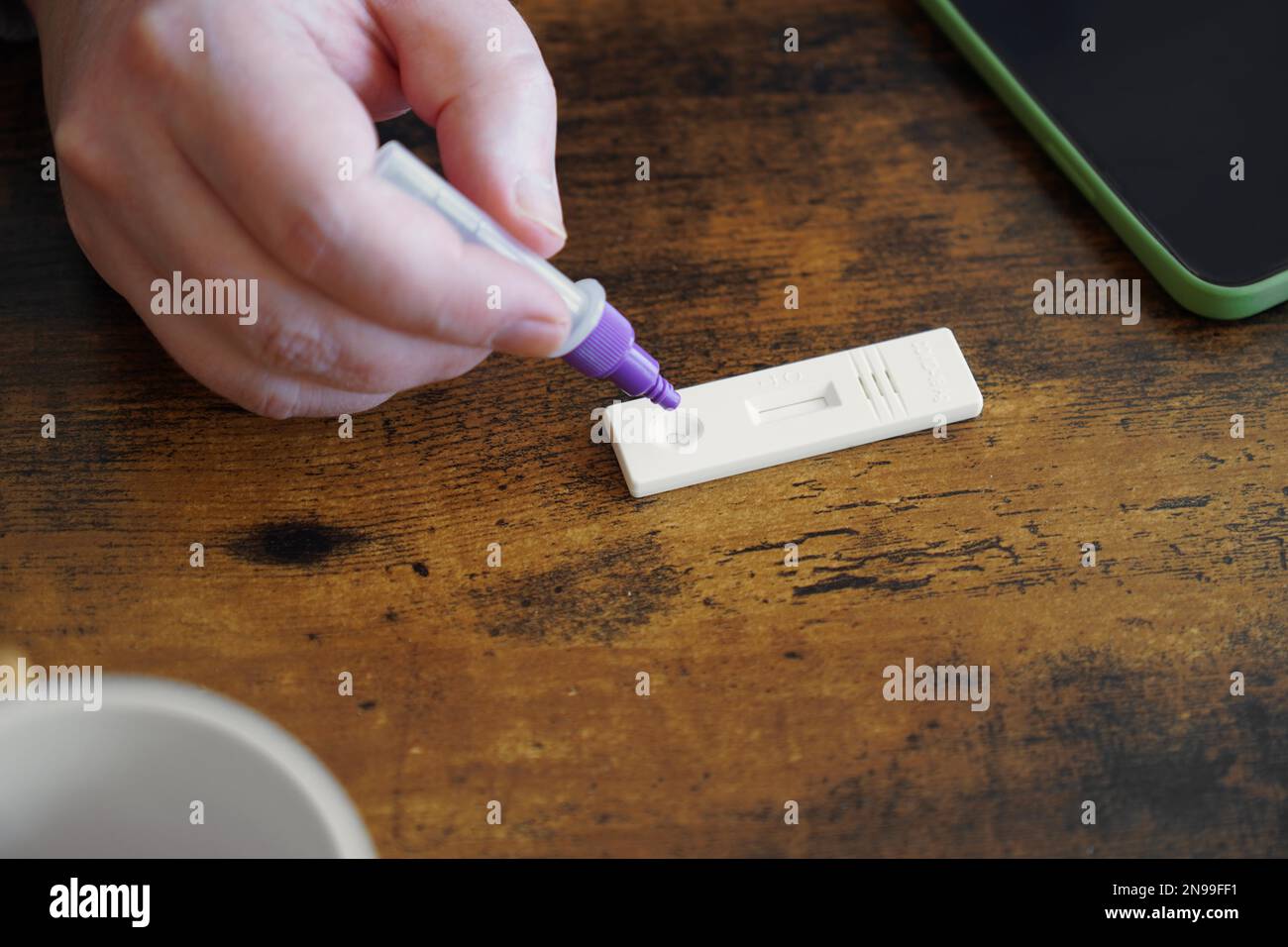 hand dropping sample from vial onto coronavirus test cassette - covid ...