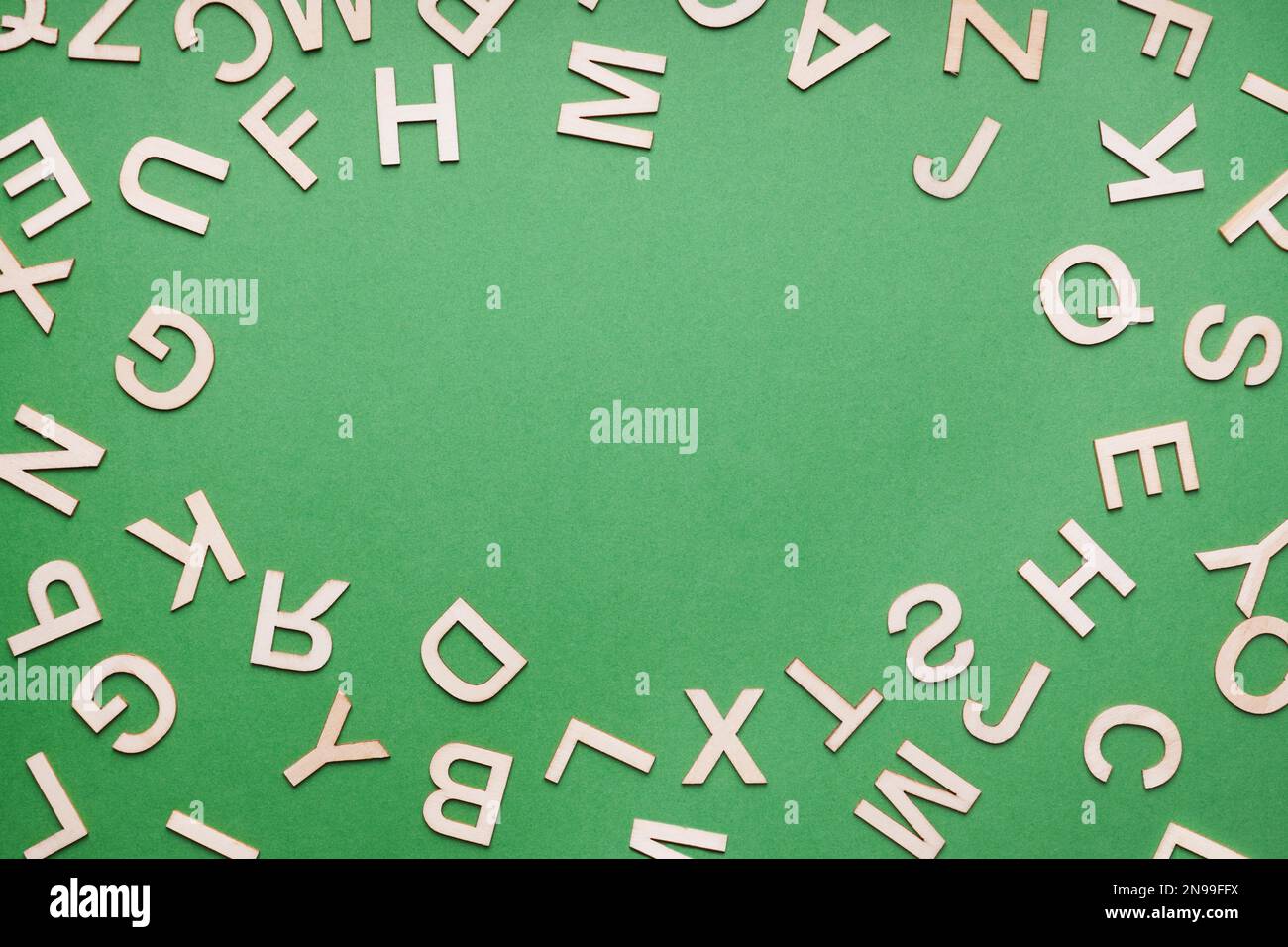 random wooden letter frame on green paper background with copy space in ...