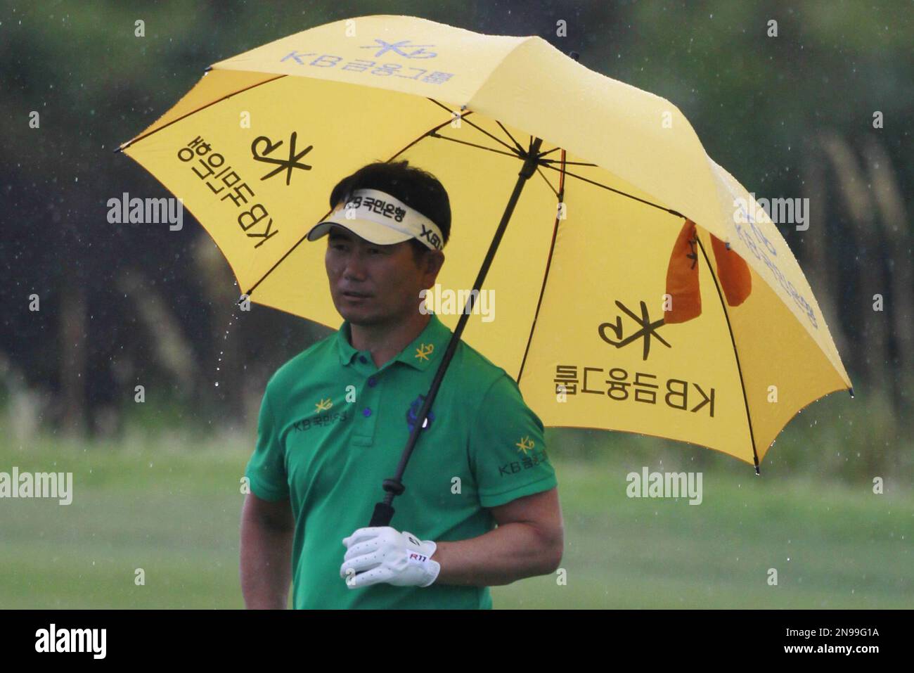 Y. E. Yang of Korea waits in the rain during a practice round for the ...
