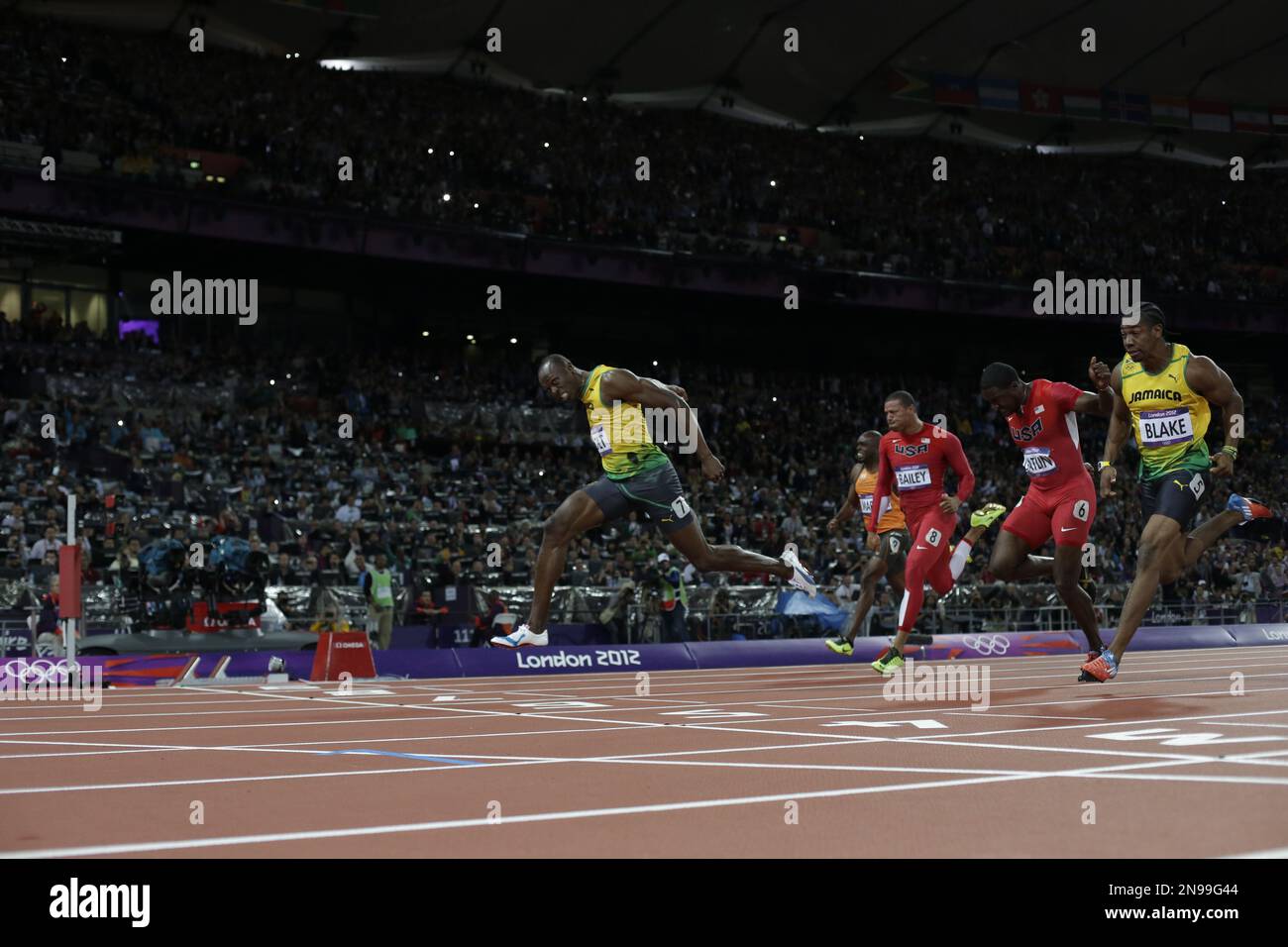 Jamaica's Usain Bolt, left, crosses the finish line ahead of Jamaica's ...
