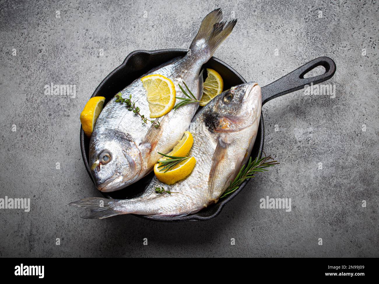 Raw fresh fish sea bream or dorado with lemon, thyme, rosemary and ...