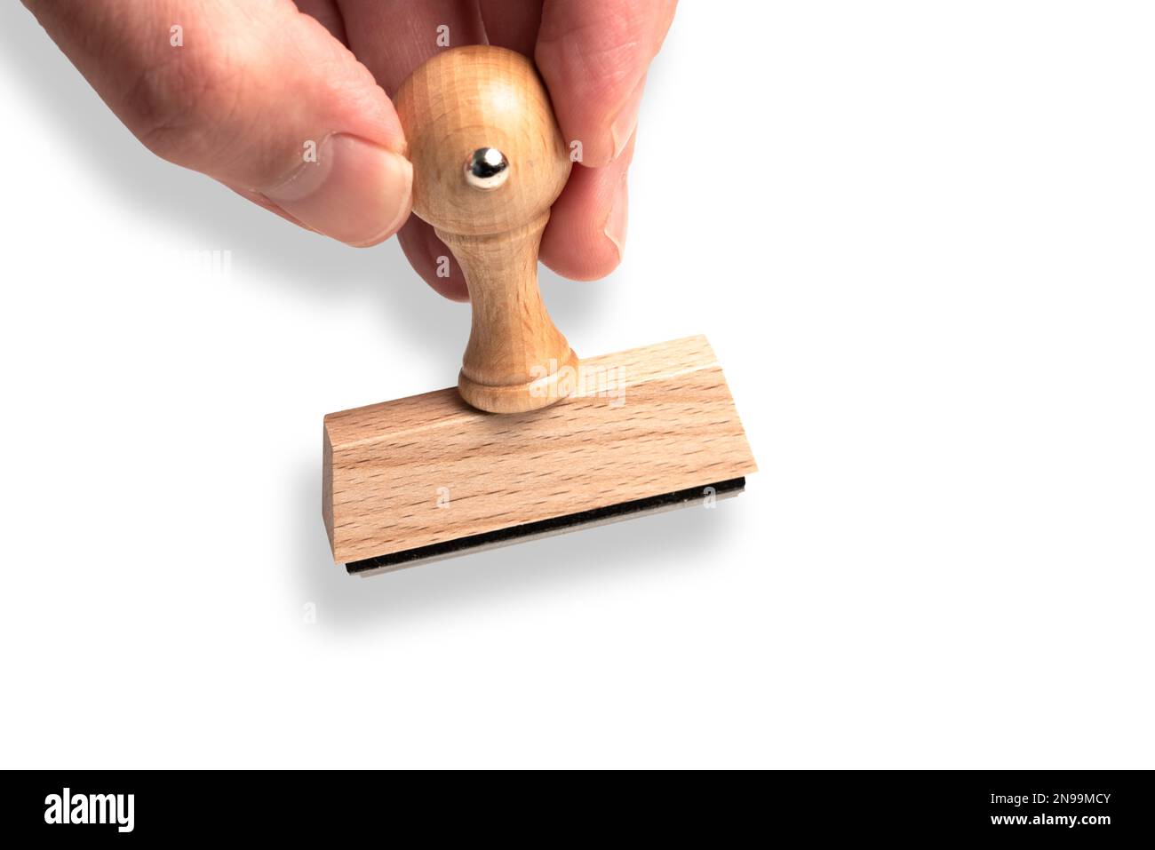 close-up of hand holding wooden rubber stamp against white background ...