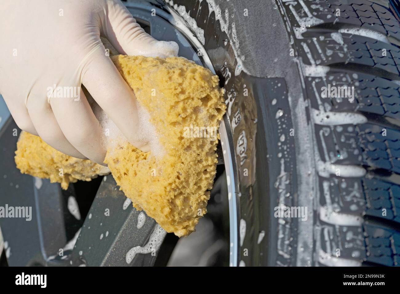 Modern aluminium rim with tyres is washed. Modern aluminium rim with ...